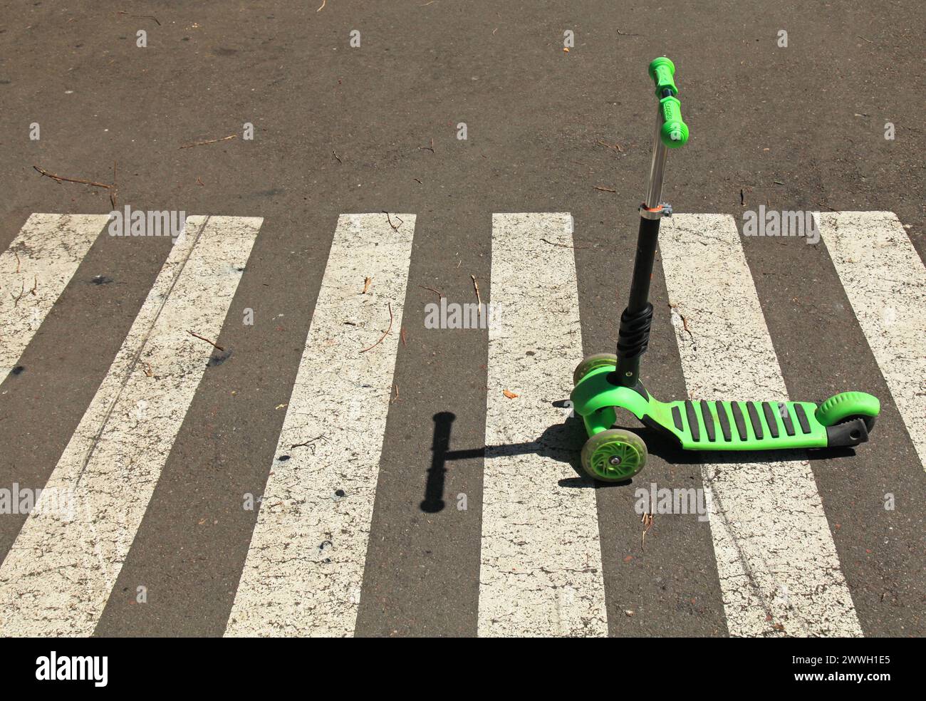 Children at the crosswalk. Children's scooter at the road. Summer ...