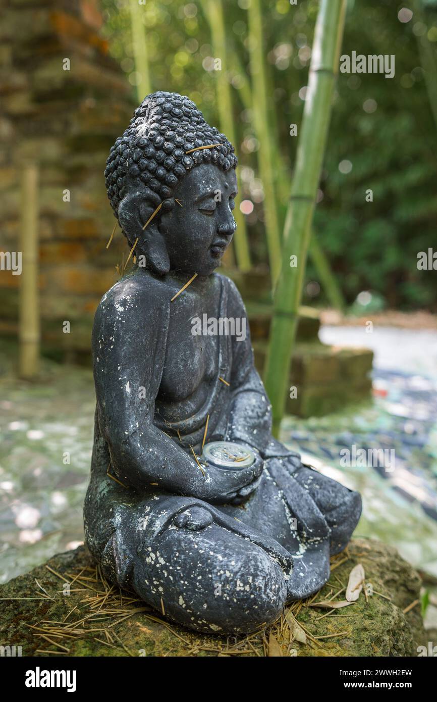 A sculpture of Buddha outdoors in nature as a religious decoration ...