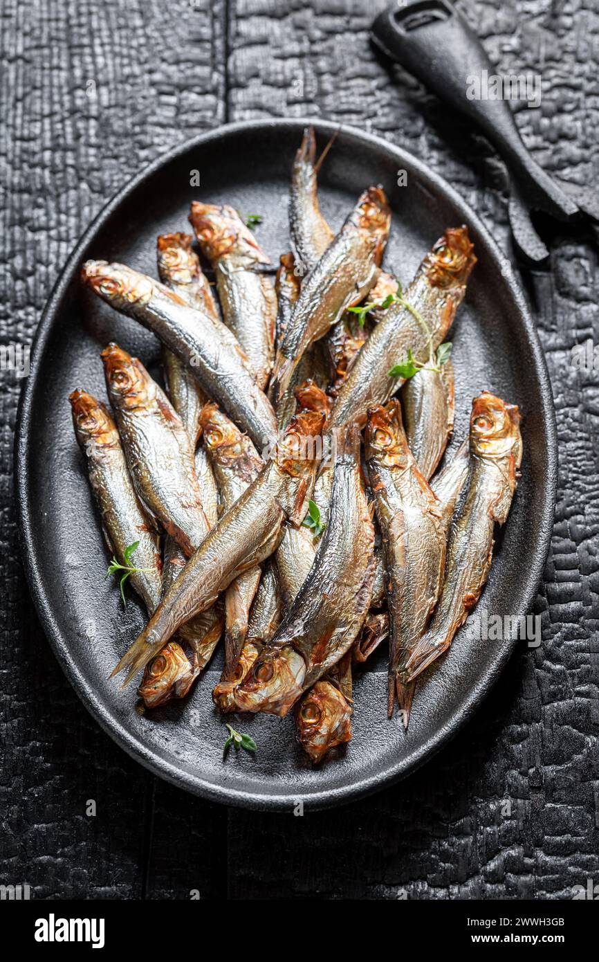 Fresh and salty smoked sprats as appetizer by the sea. Smoked fish ...
