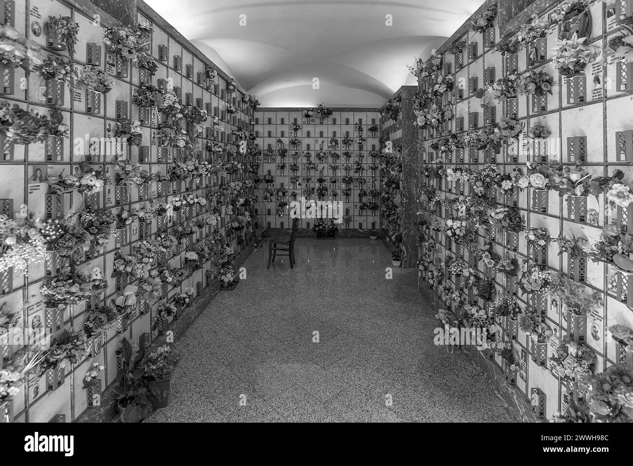 Graves with floral decorations in a hall at the Monumental Cemetery ...