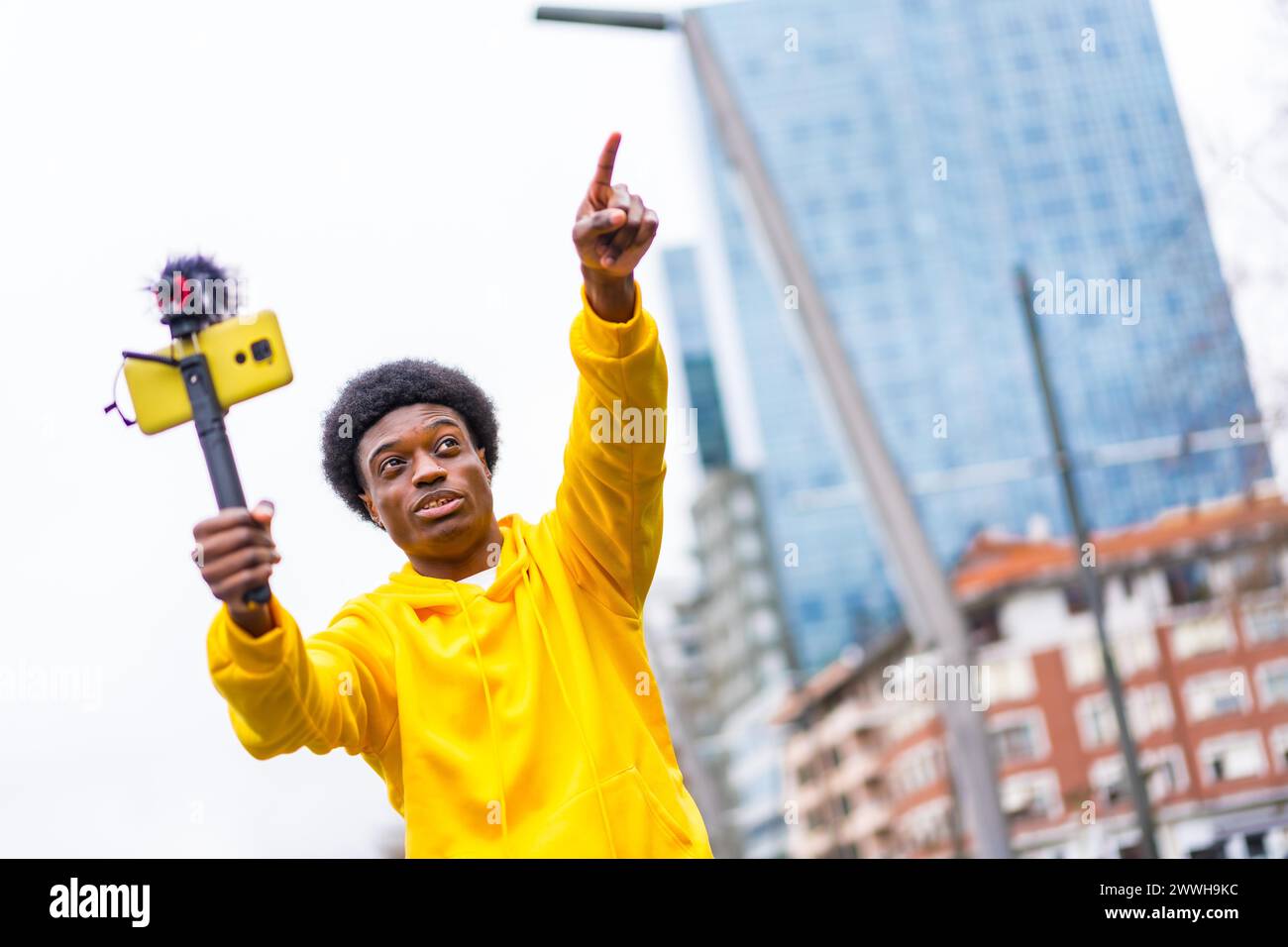 African young vlogger pointing ahead during an online video with a ...