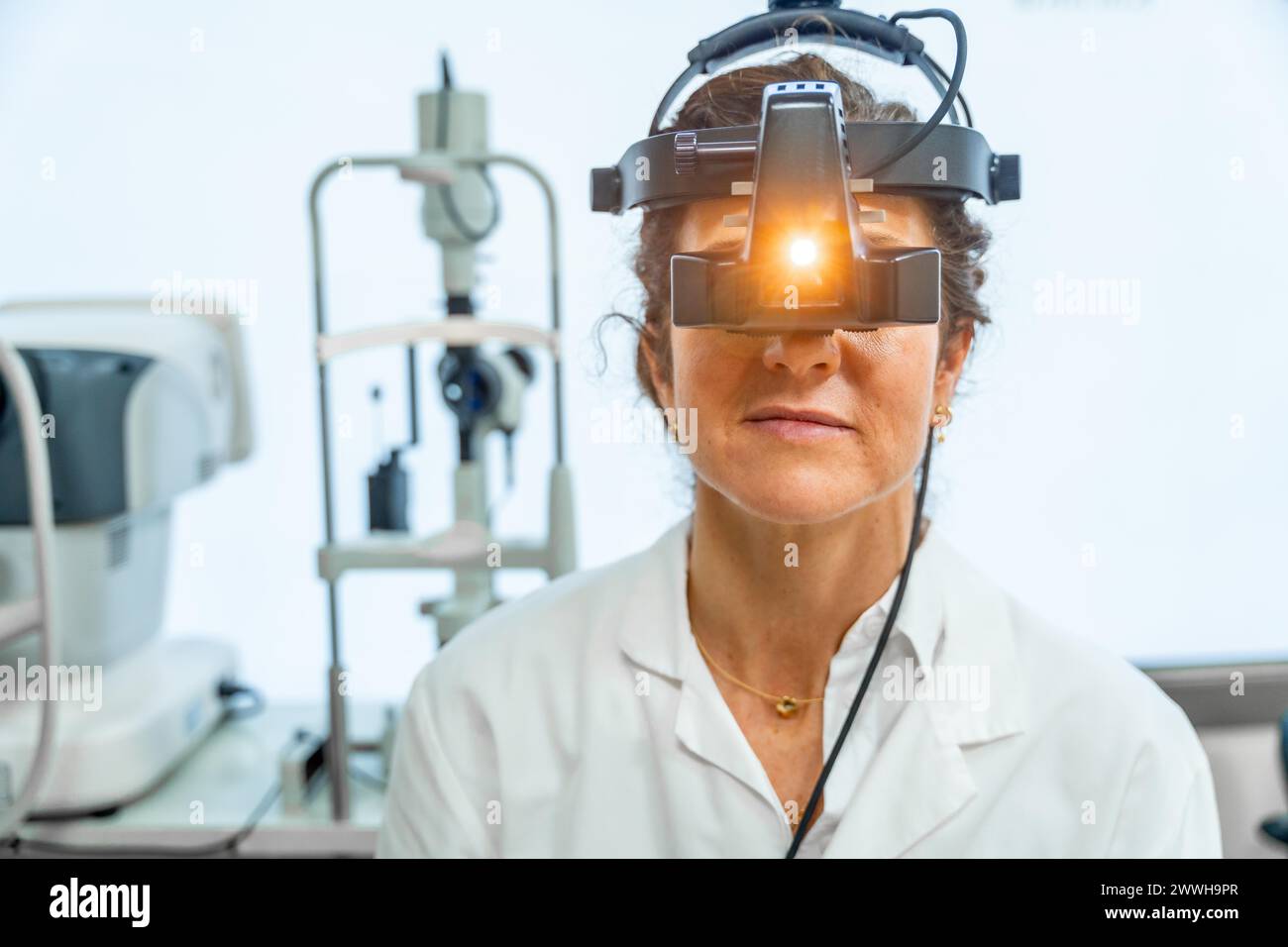 Portrait frontal view of female ophthalmologist using the light of a ...