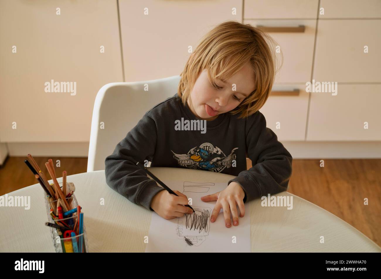 Indoor photo, boy, 4-5 years, blond, drawing on sheet of paper, pencils ...
