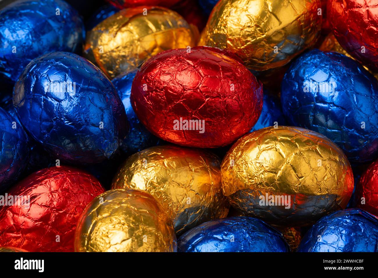 Chocolate easter eggs in colorful tinfoil close up full frame as ...