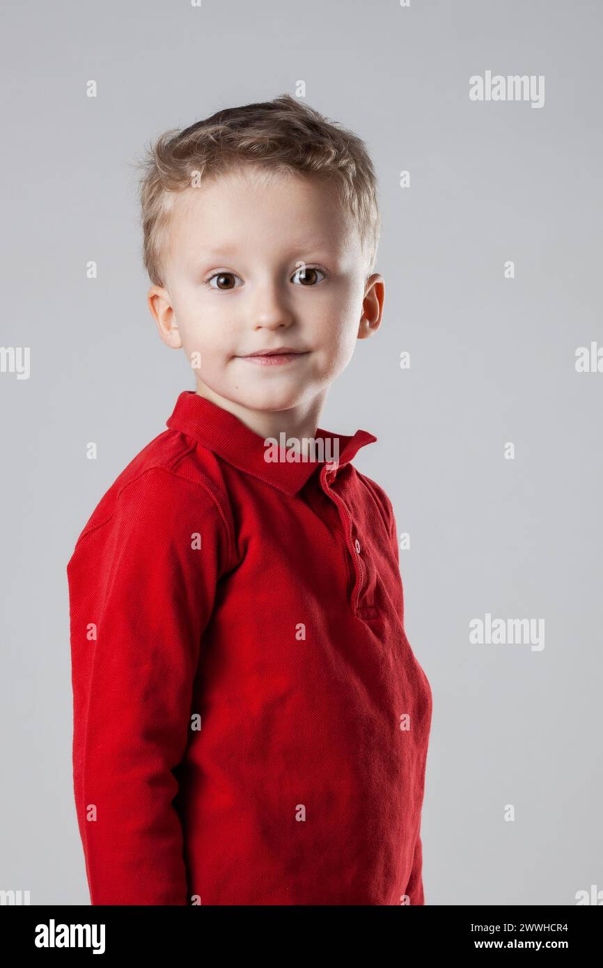 Portrait of a happy little boy in red blouse standing upright and ...