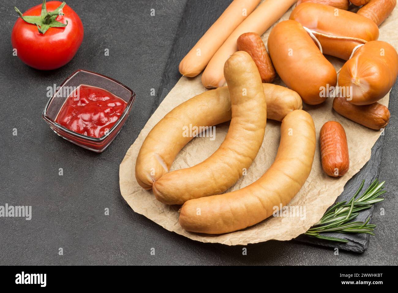 Sausages of different varieties on paper. Tomato paste and tomato on ...