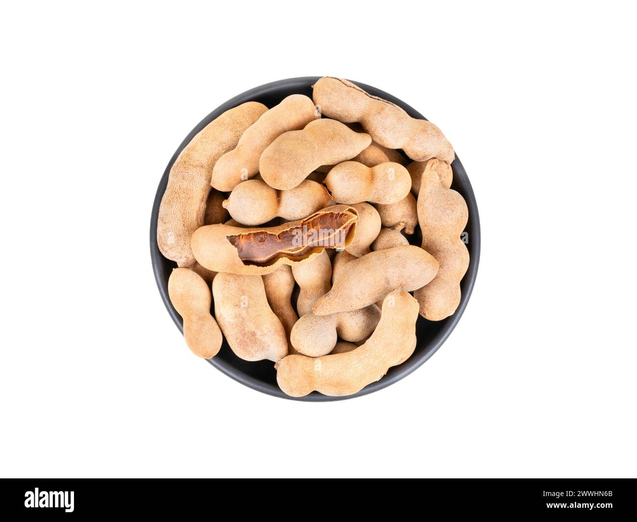 Black bowl full of tamarind fruits in shell isolated on white ...