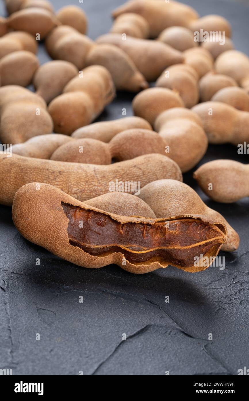 Scattered tamarind fruits in shell on dark background Stock Photo - Alamy