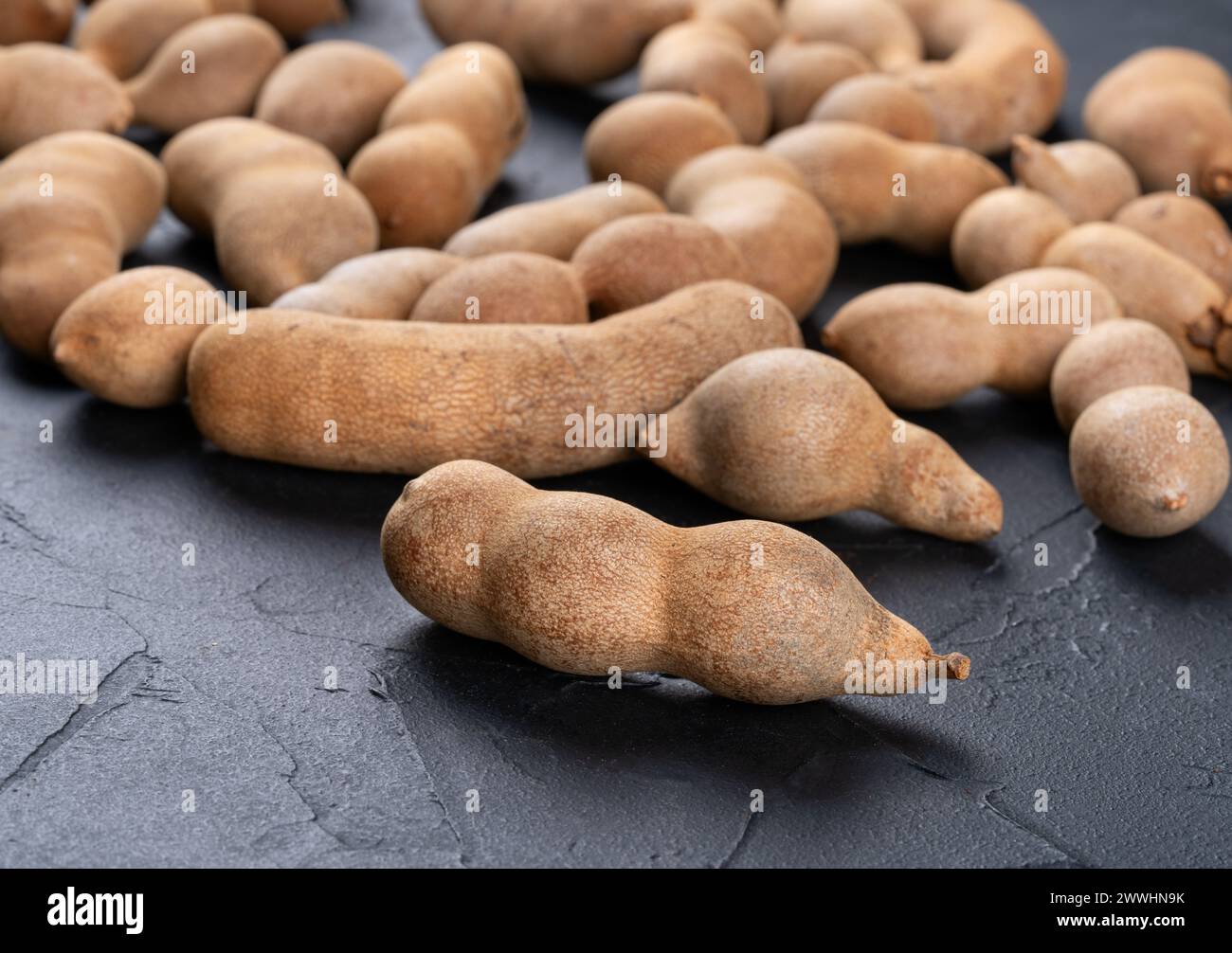 Scattered tamarind fruits in shell on dark background, close-up Stock ...