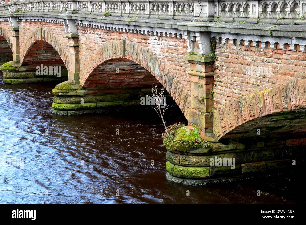 Stone arches of a river road bridge in an urban town river location ...