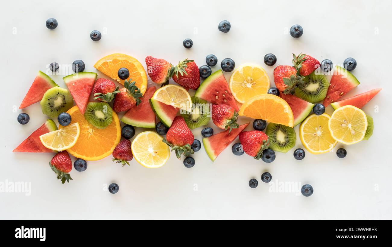 A narrow rectangle cluster of fresh fruit pieces against a white ...