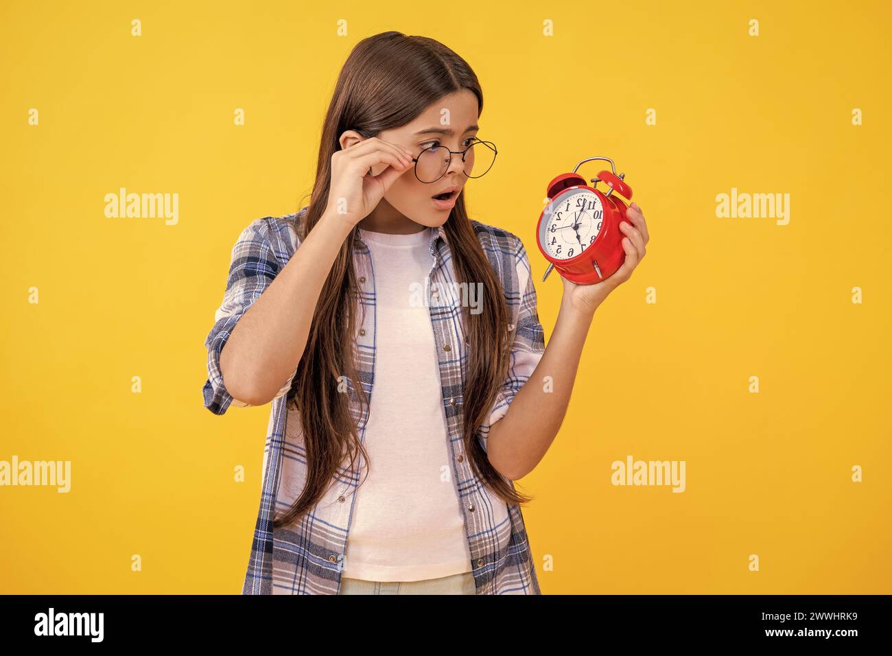 Teen girl checking school time schedule with alarm clock Teen girl ...