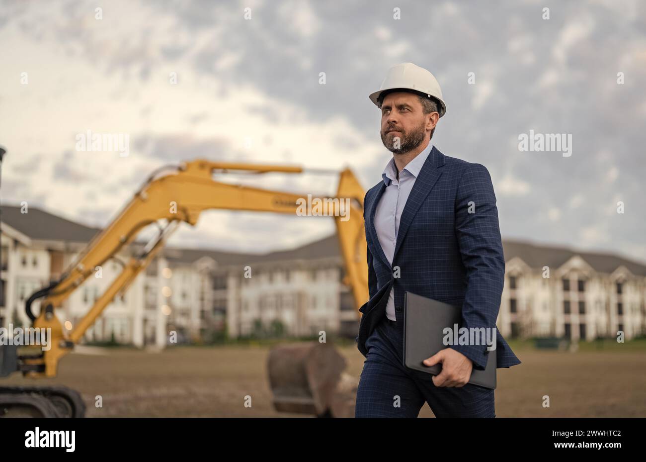 image of businessman with building plan wearing hardhat, copy space ...