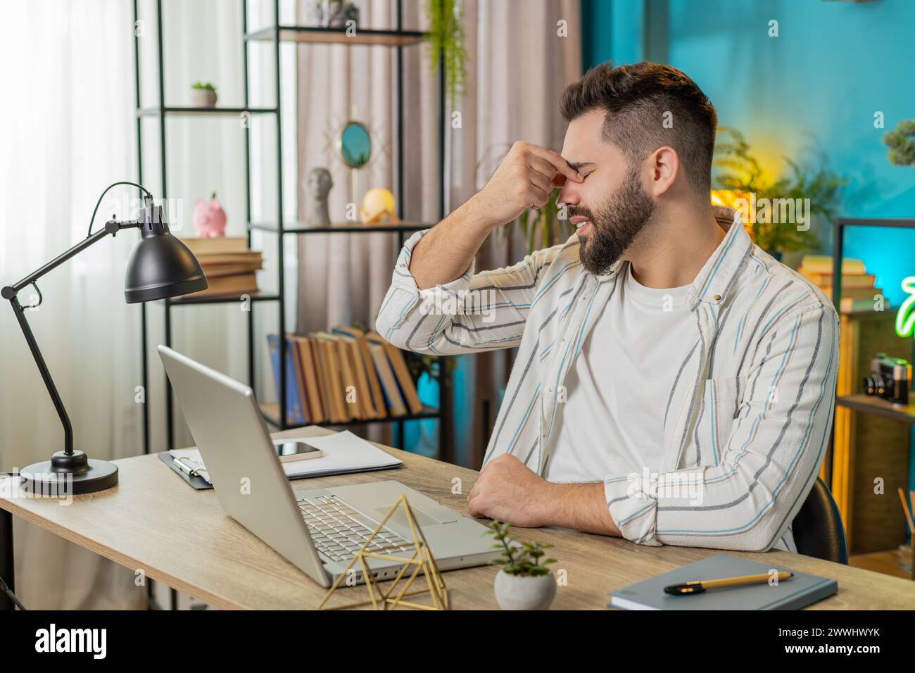Bored sleepy business man worker working on laptop computer, rubbing ...