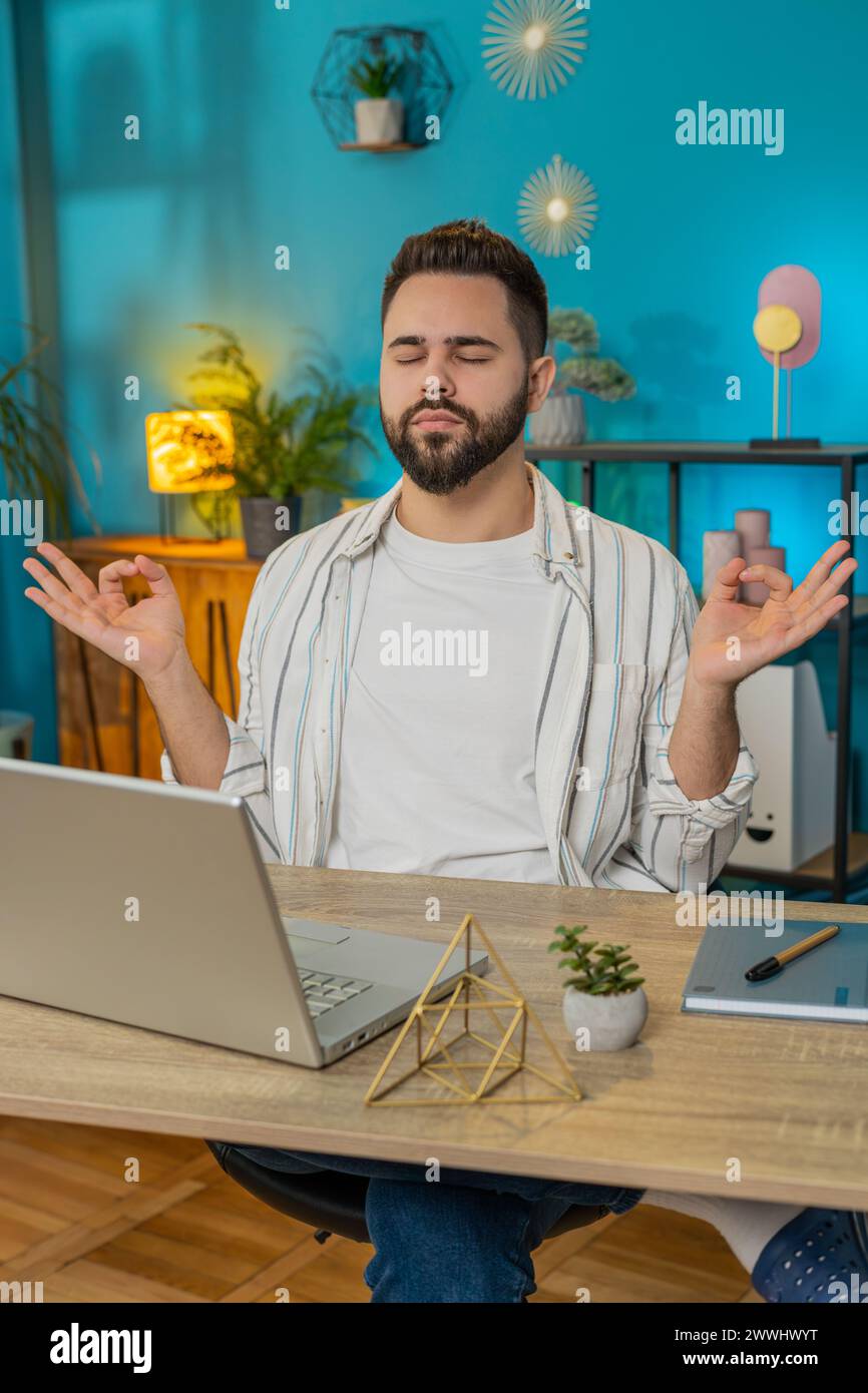 Peaceful relaxed male worker businessman sitting at workplace with ...