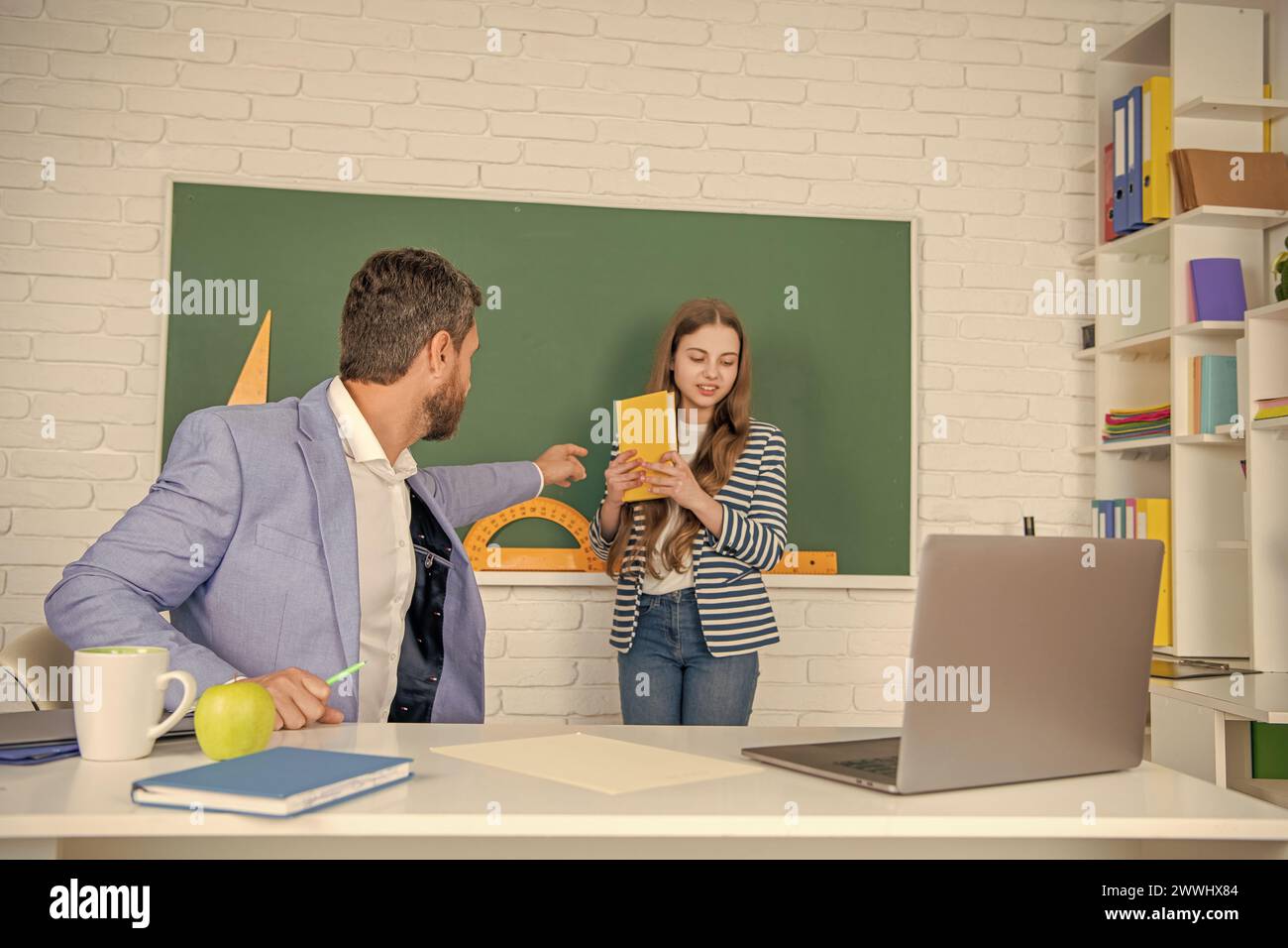 school teacher with selective focus of child at blackboard. point ...
