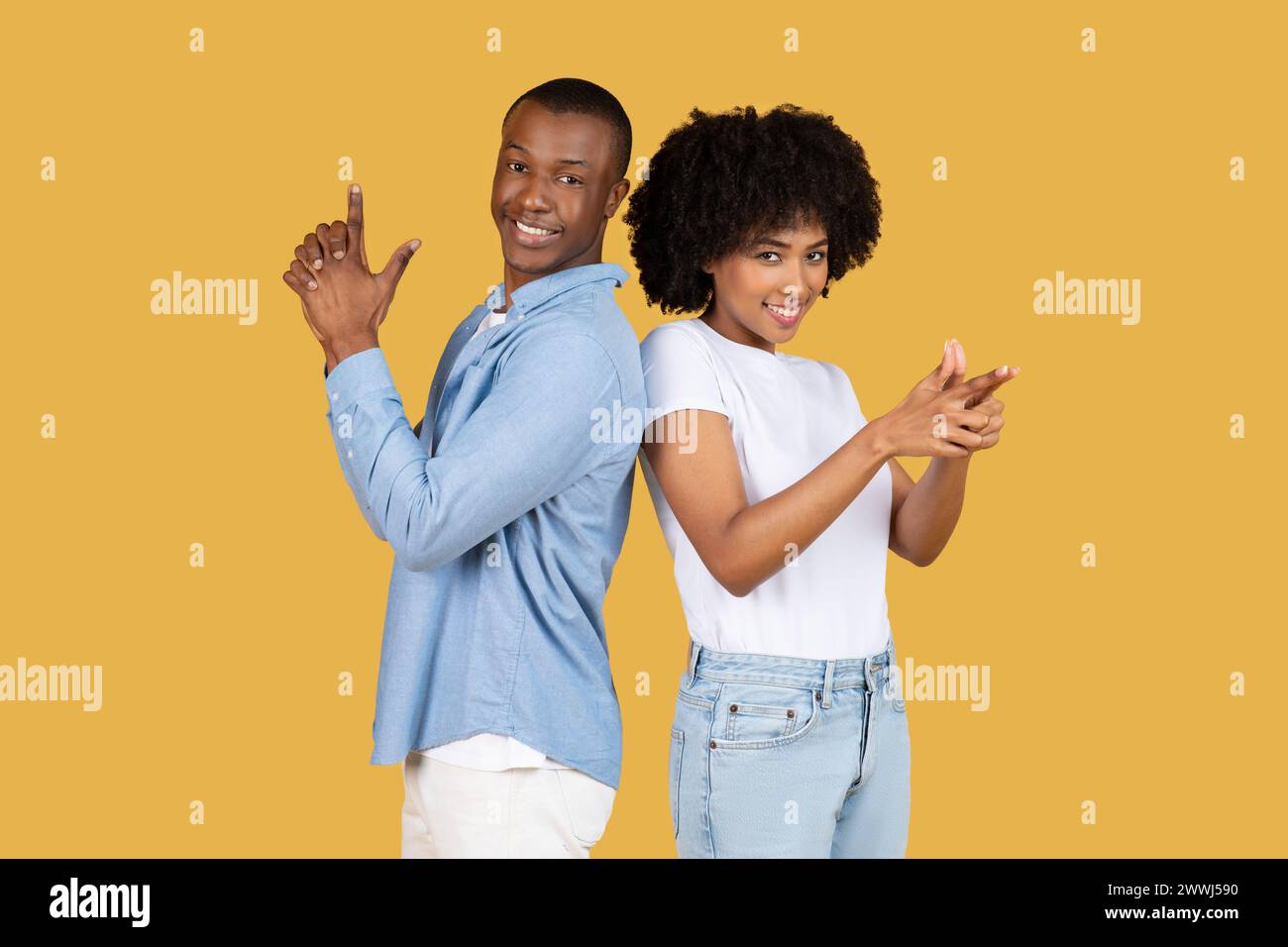 Back-to-back African American couple confidently showing hand signs ...