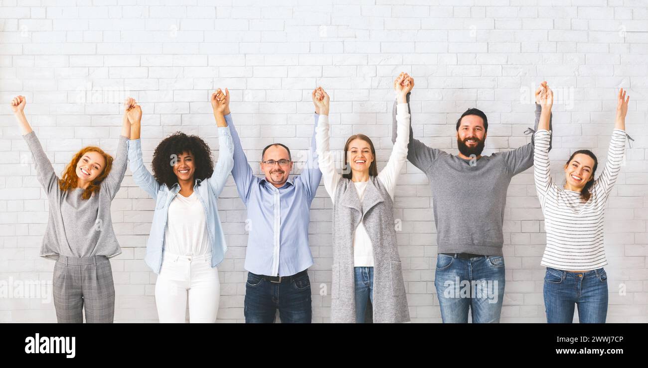 Group of successful friendly people raising connected hands Stock Photo ...