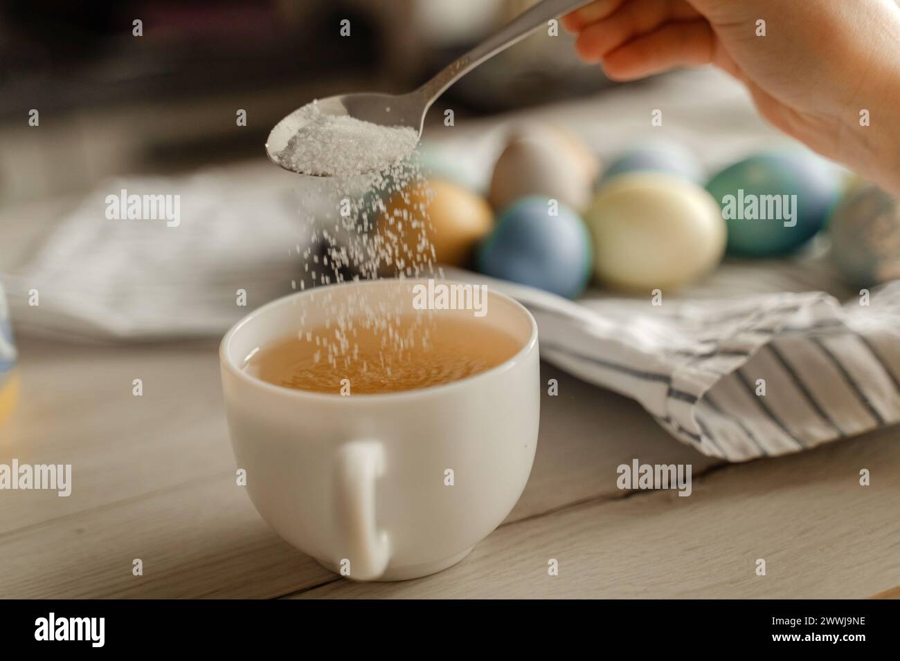 A persons hand is seen sprinkling sugar from a small bowl onto the ...