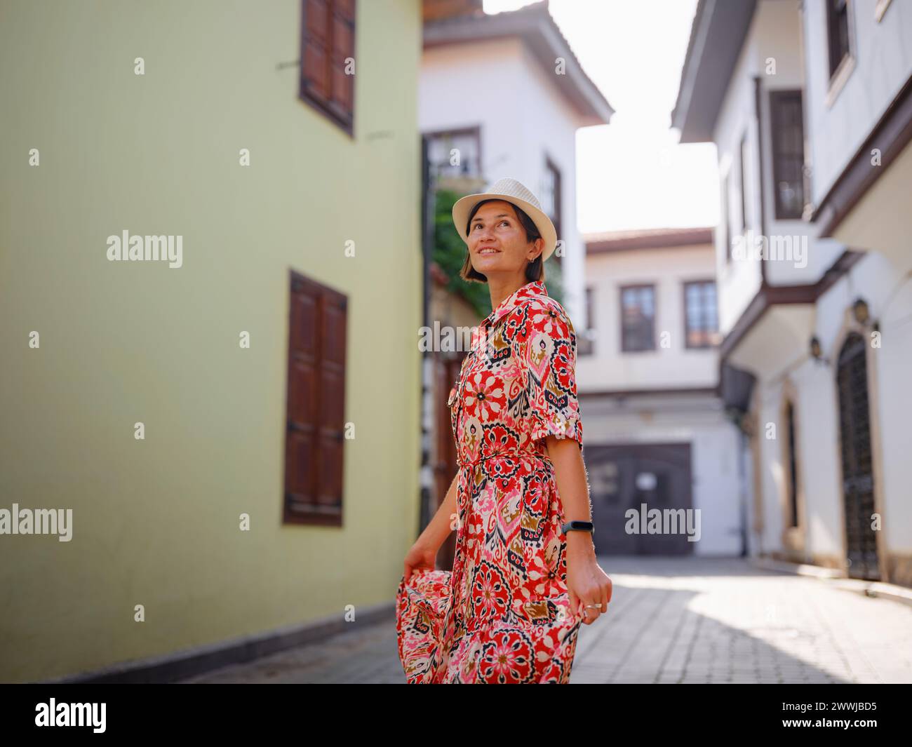 female summer travel to Antalya, Turkey. young asian woman in red dress walk through old town ...