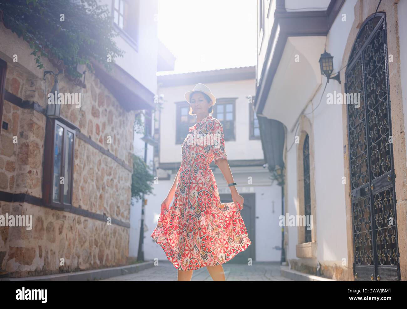 female summer travel to Antalya, Turkey. young asian woman in red dress walk through old town ...