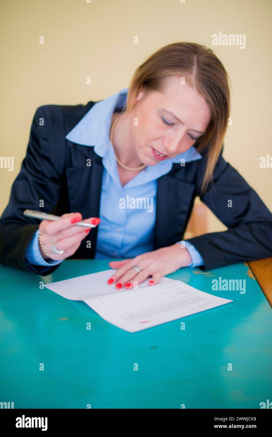 Blonde female signing form Tilburg, Netherlands. Attractive blonde ...