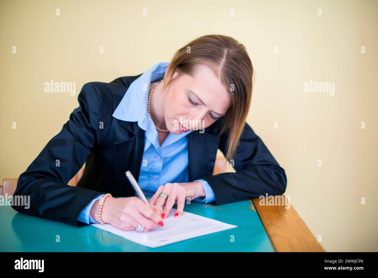 Blonde female signing form Tilburg, Netherlands. Attractive blonde ...