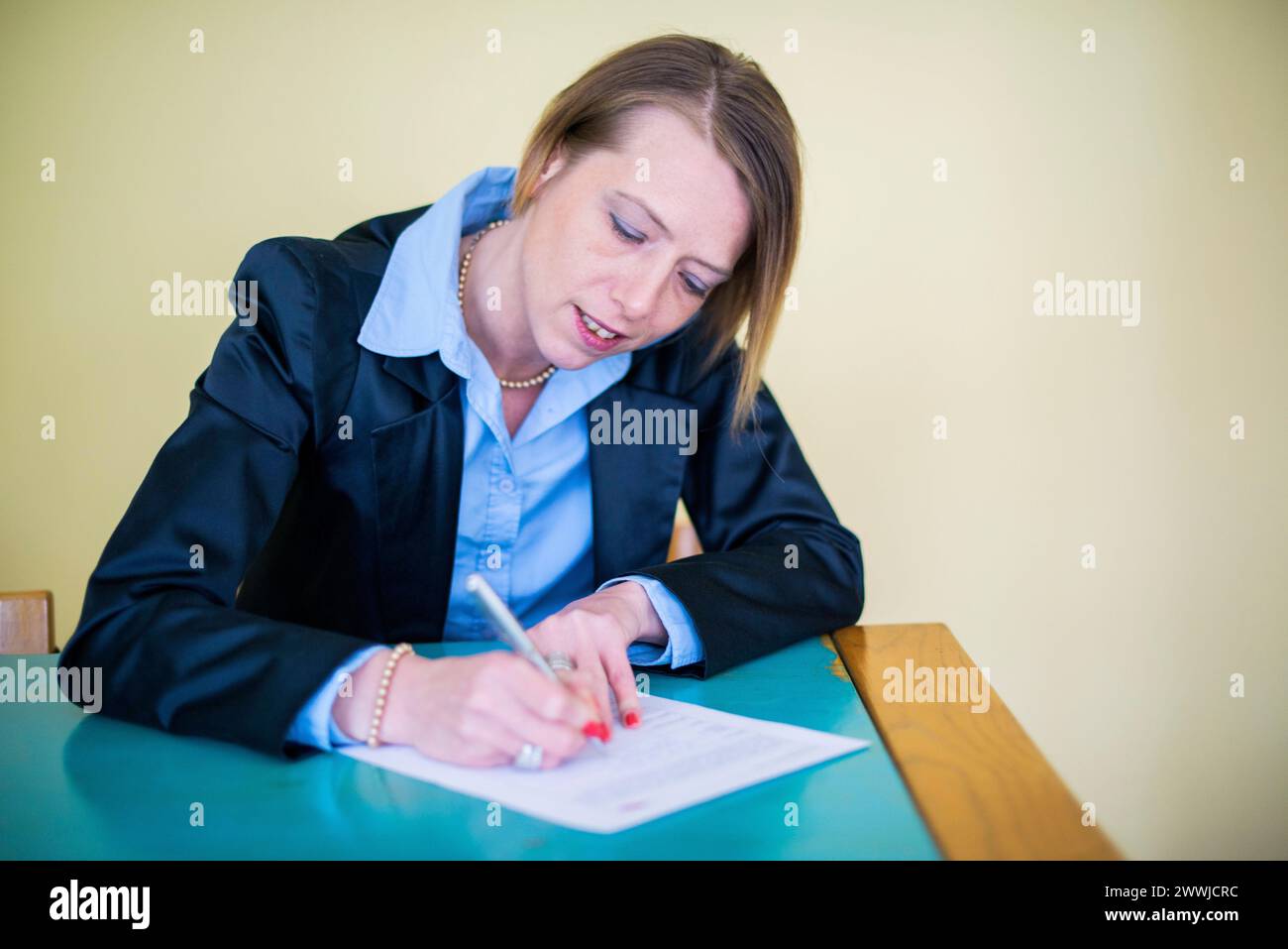 Blonde female signing form Tilburg, Netherlands. Attractive blonde ...