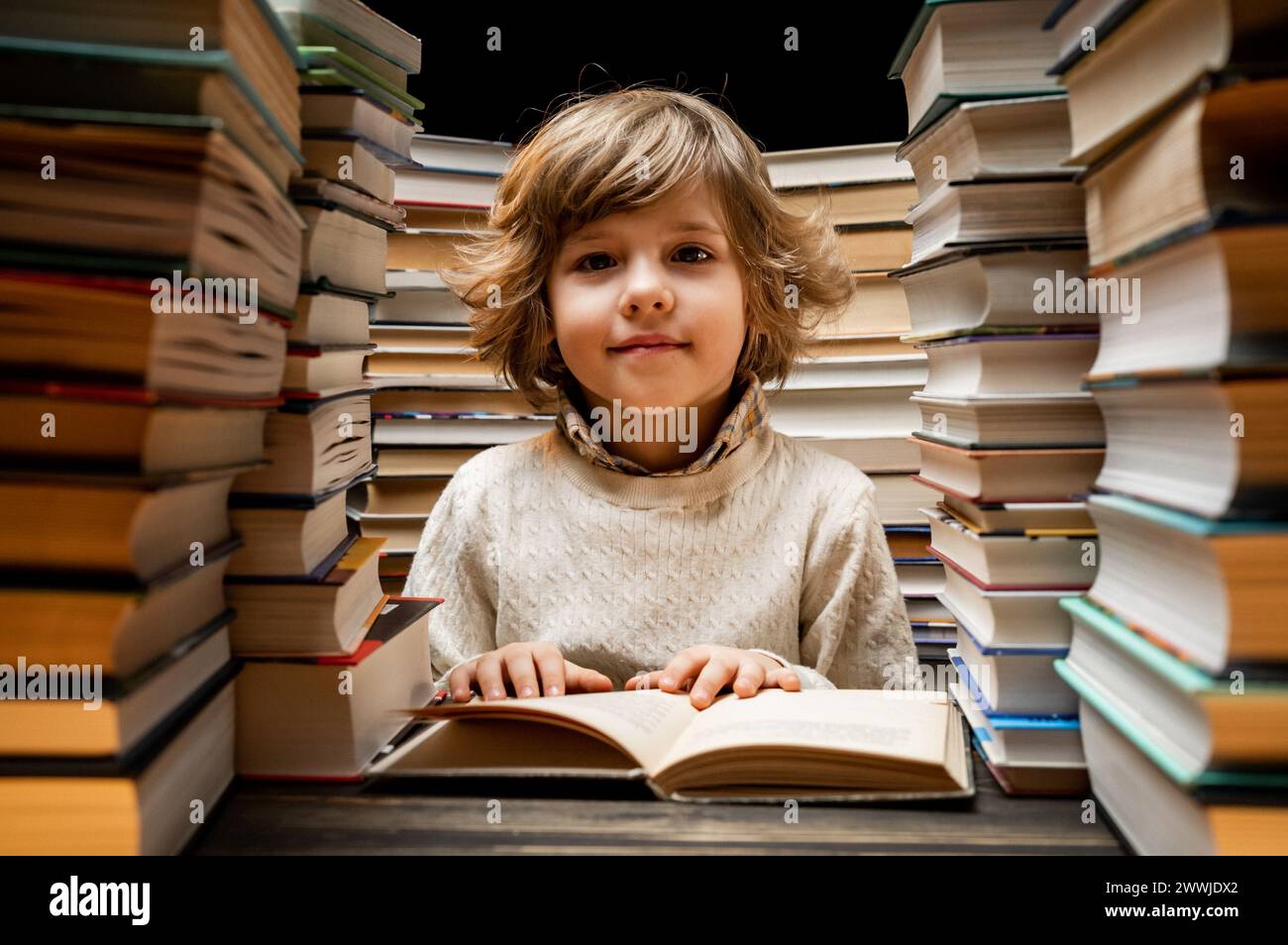 Handsome little child flips through book pages in library. Elementary ...