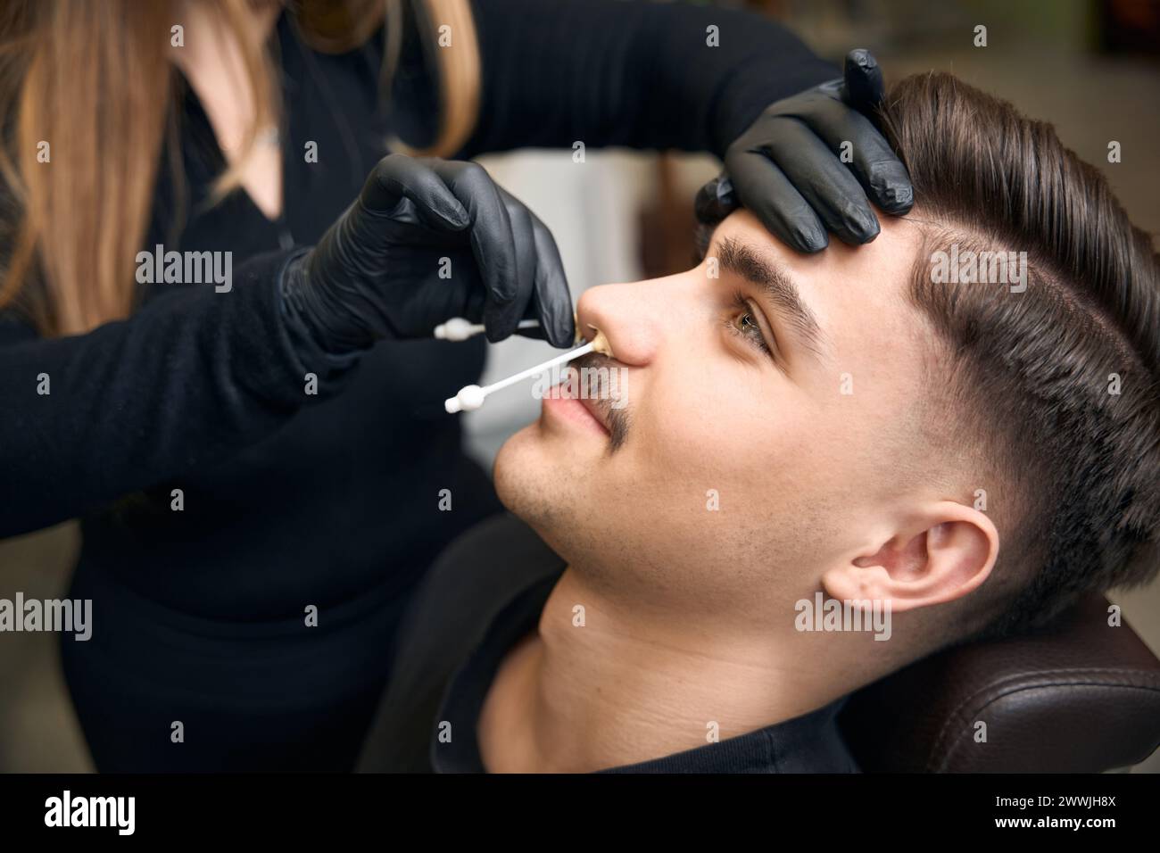 Master barber doing depilation beauty procedure in barbershop Stock ...