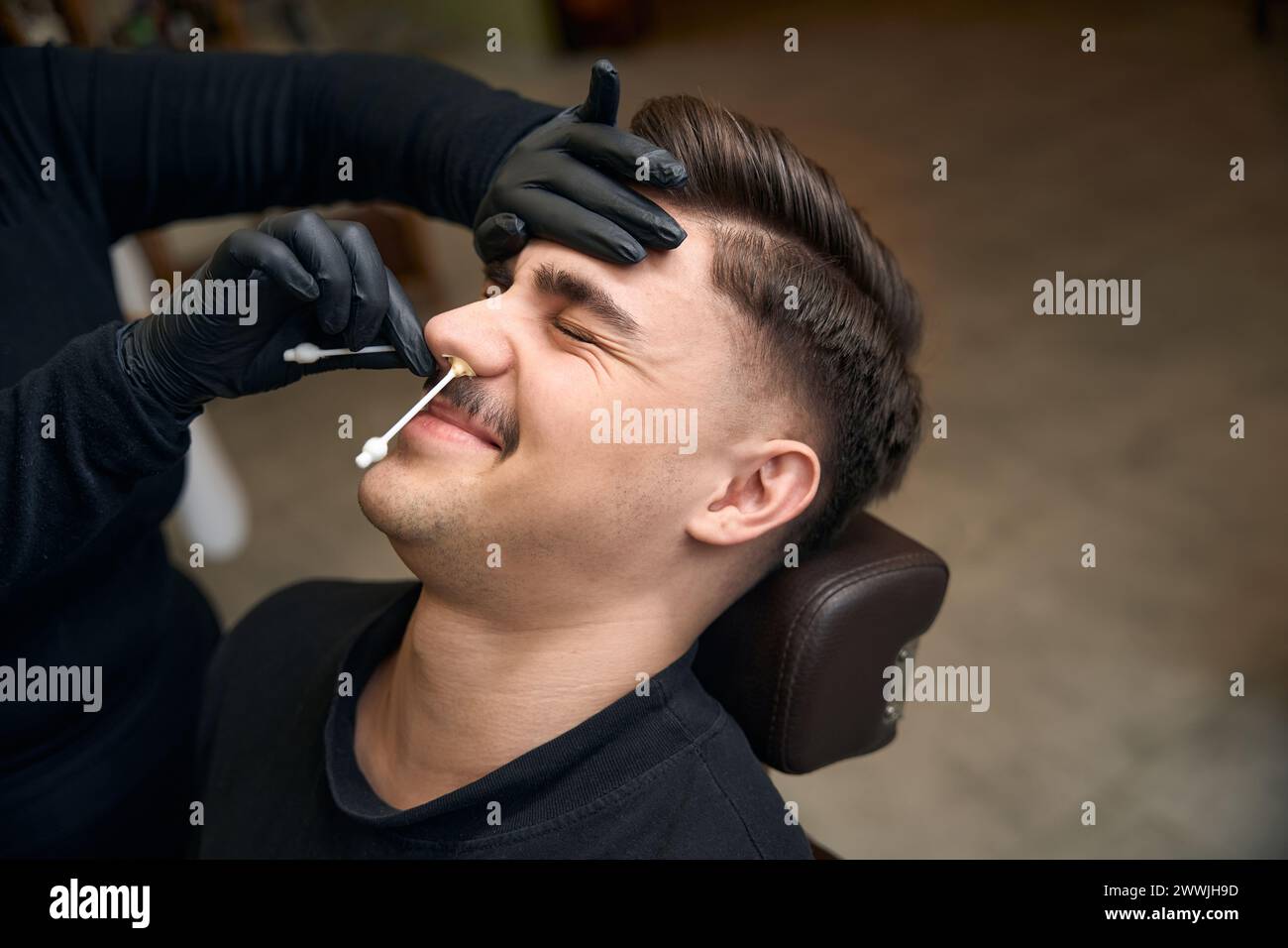 Master barber doing depilation beauty procedure in barbershop Stock ...
