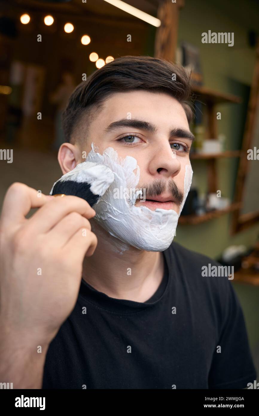 Attractive man shaving himself at workplace Stock Photo - Alamy