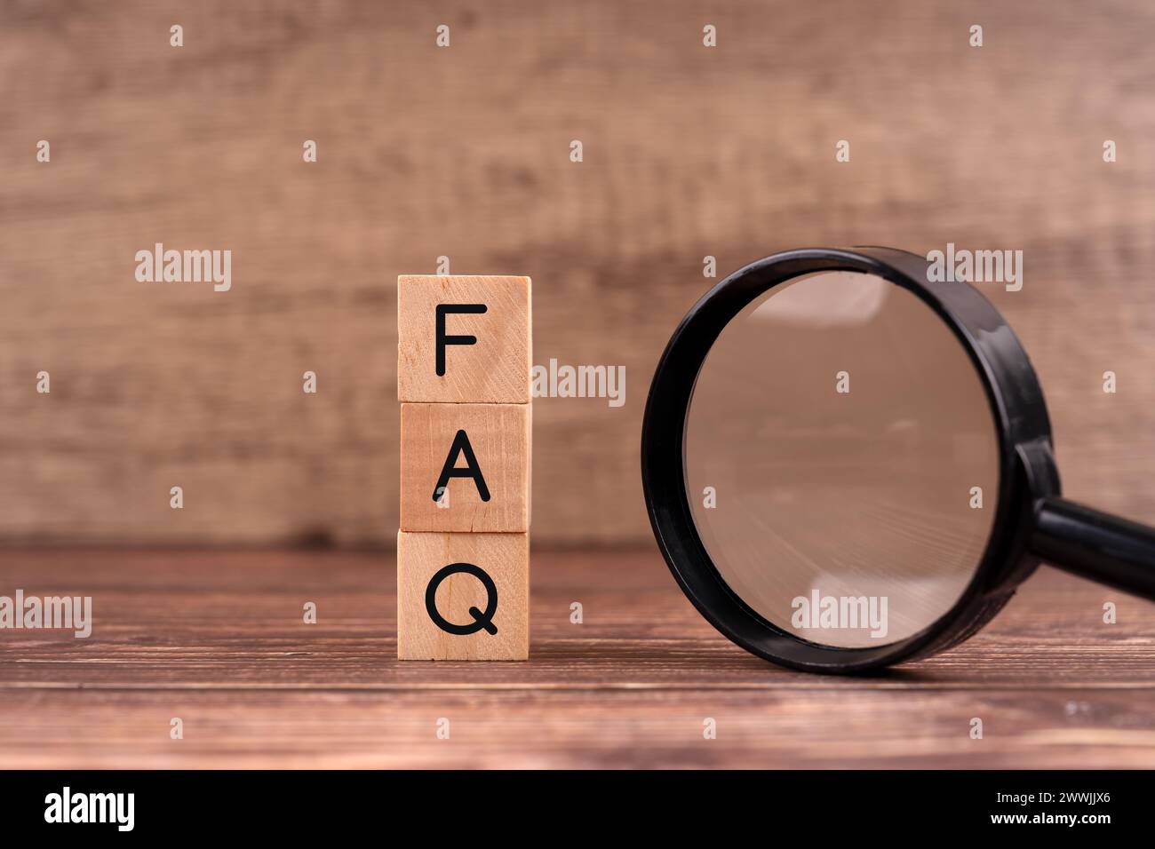 Faq word on wood block and magnifying glass Stock Photo - Alamy