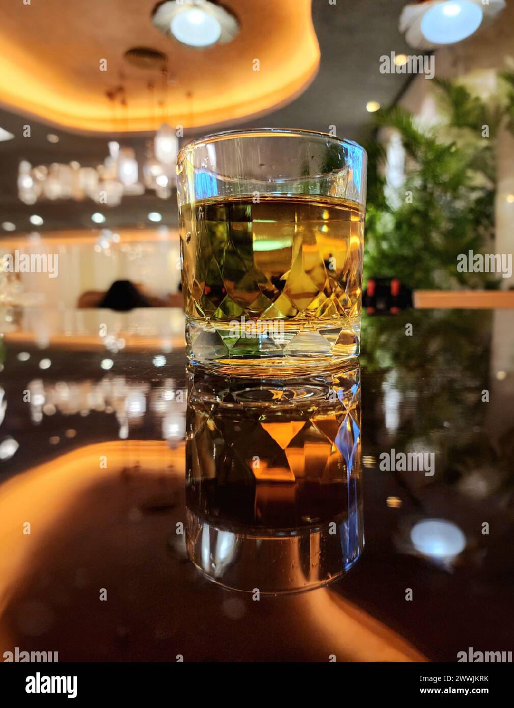 A reflection of a whiskey drink, the cut glass and the color on the ...