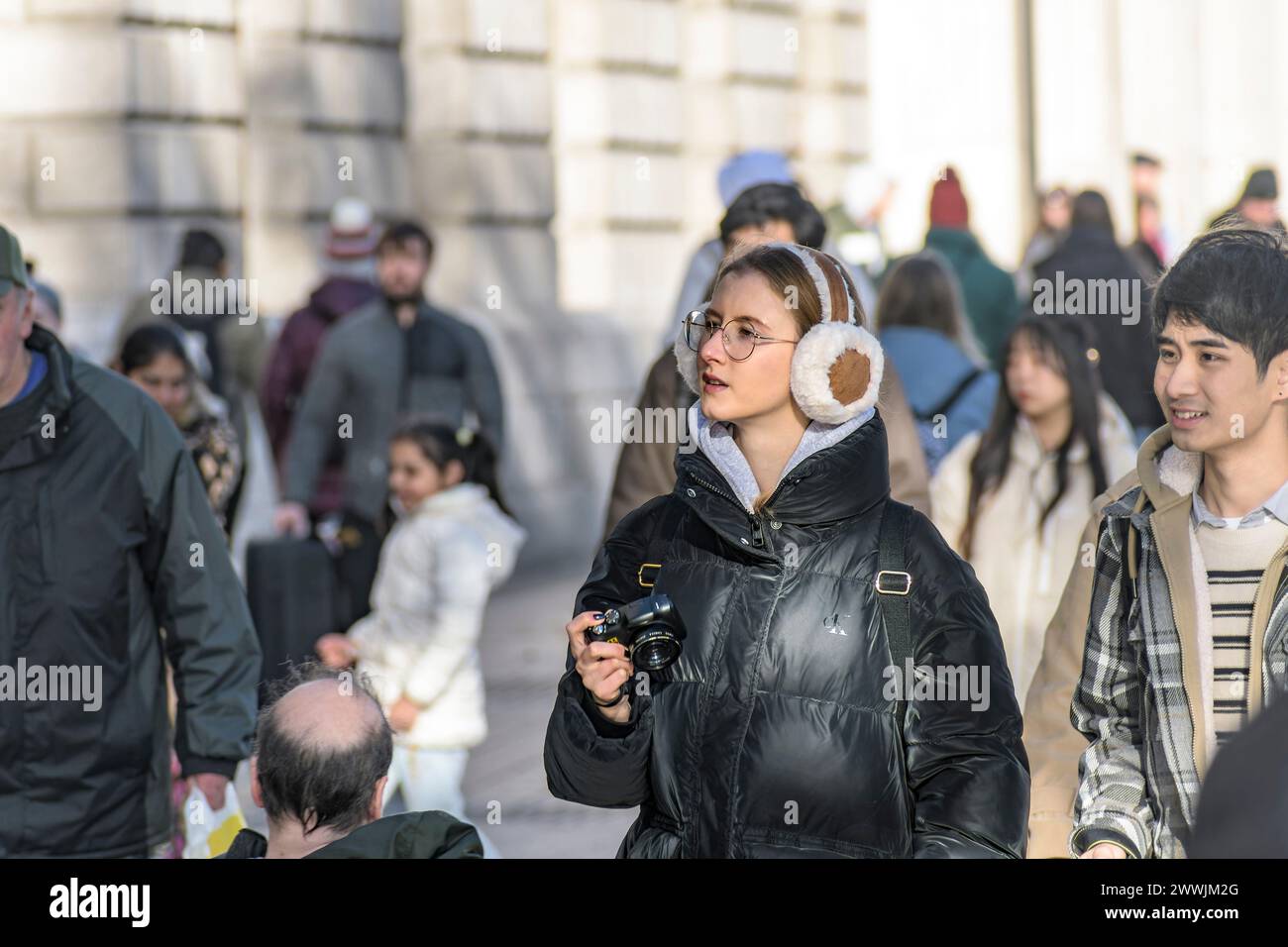 Street portrait of a relaxed young happy stylish woman with a camera in ...