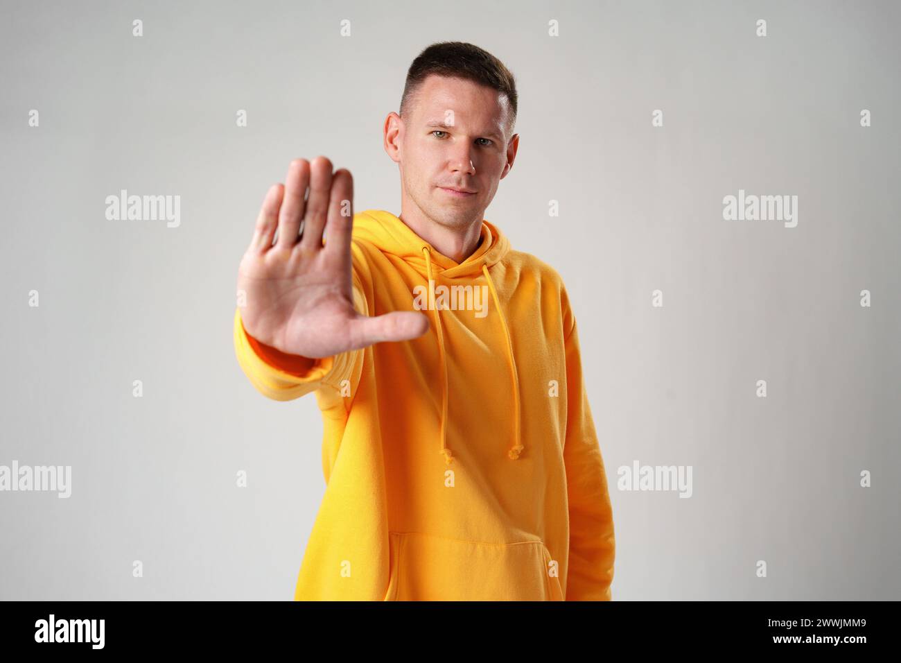 Man showing hand palm stop gesture against gray background Stock Photo ...
