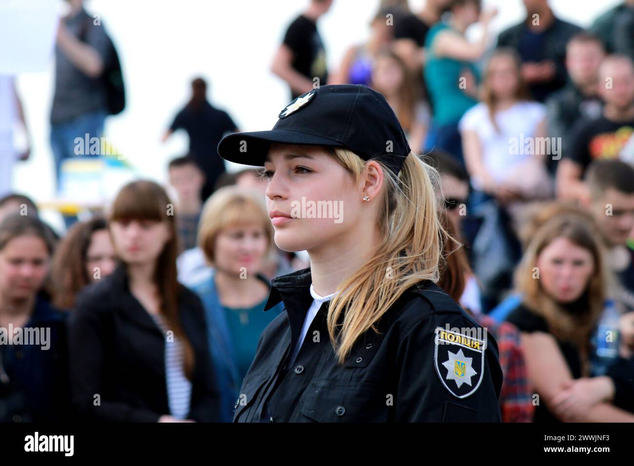 A beautiful girl patrol police officer is standing on street ...