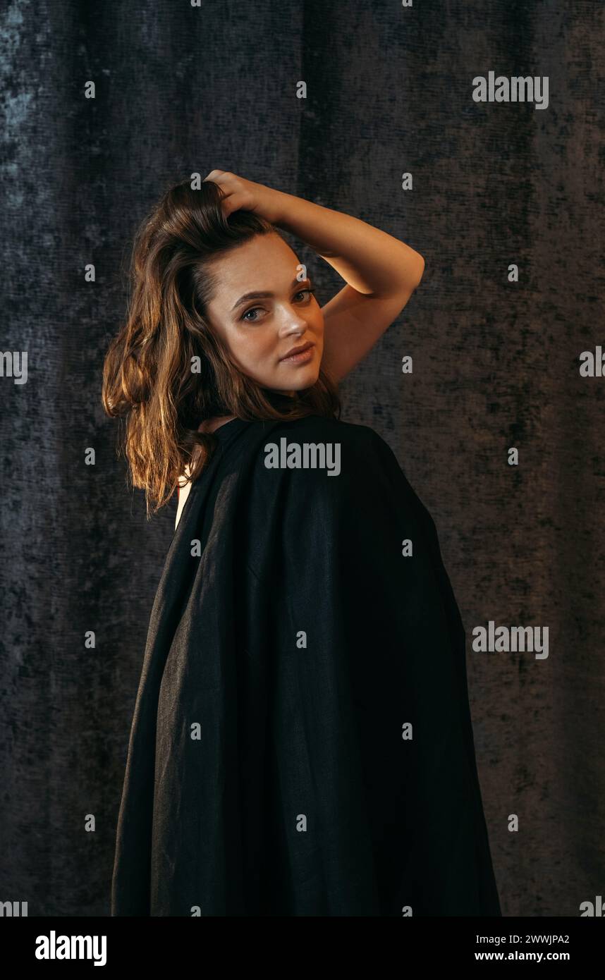 A woman wearing a black top striking a pose for a picture. Vertical ...