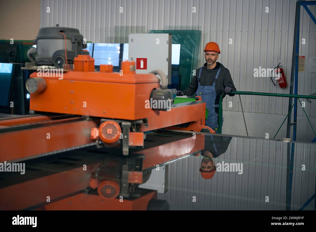 Man uses an automatic glass cutting table in window production Stock ...