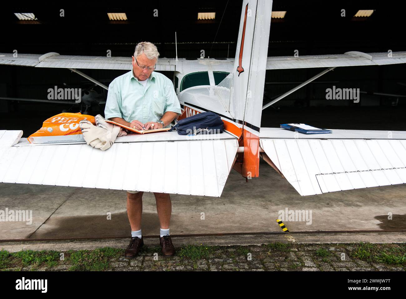 Pilot filing log Seppe Airport, Netherlands. Small Cesna Pilot working ...