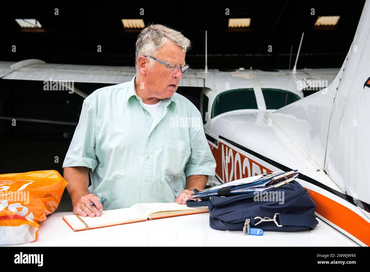 Pilot filing log Seppe Airport, Netherlands. Small Cesna Pilot working ...