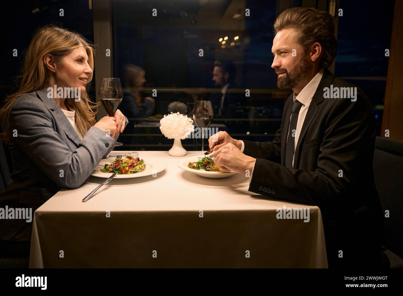 Female and male are talking over dinner in cozy restaurant Stock Photo ...