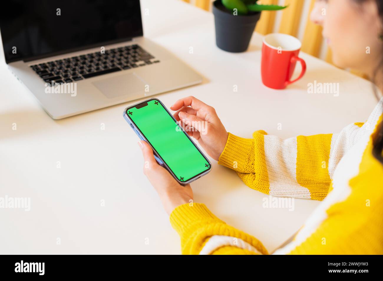 Close-up unrecognizable woman in a sweater working in using a blank ...