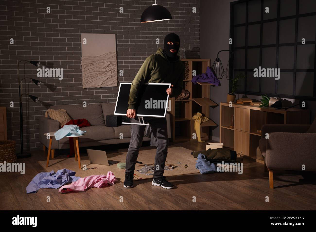 Male thief stealing monitor in room at night Stock Photo - Alamy