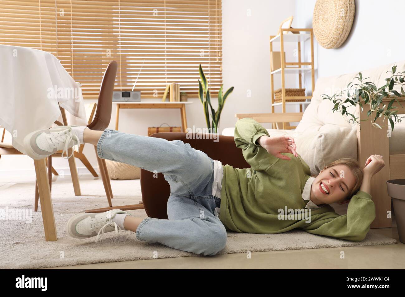 Young woman fell from chair at home. Trauma concept Stock Photo - Alamy