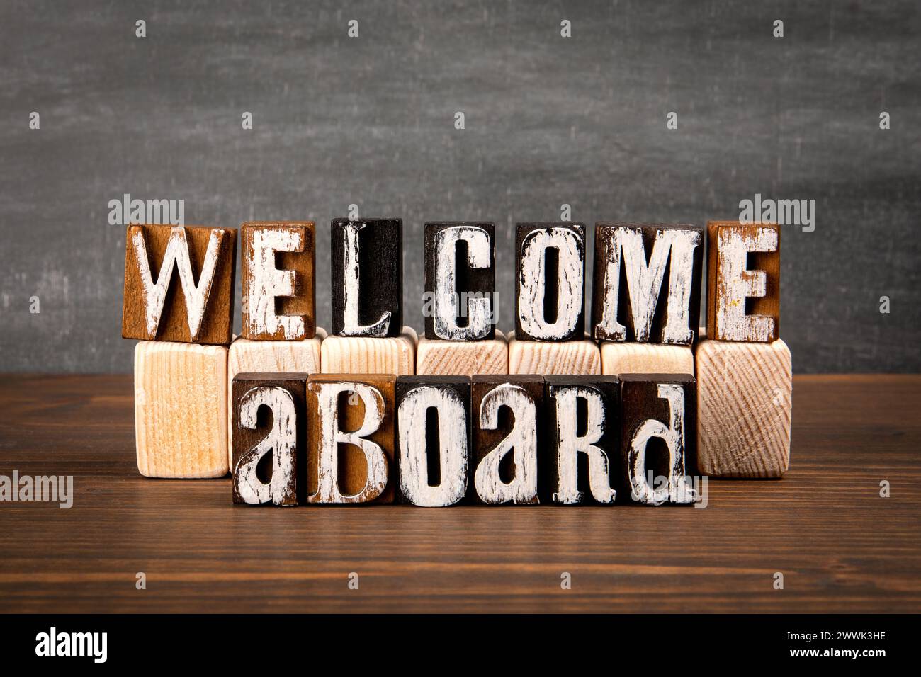 WELCOME ABOARD Concept. Alphabet blocks on wood and blackboard ...