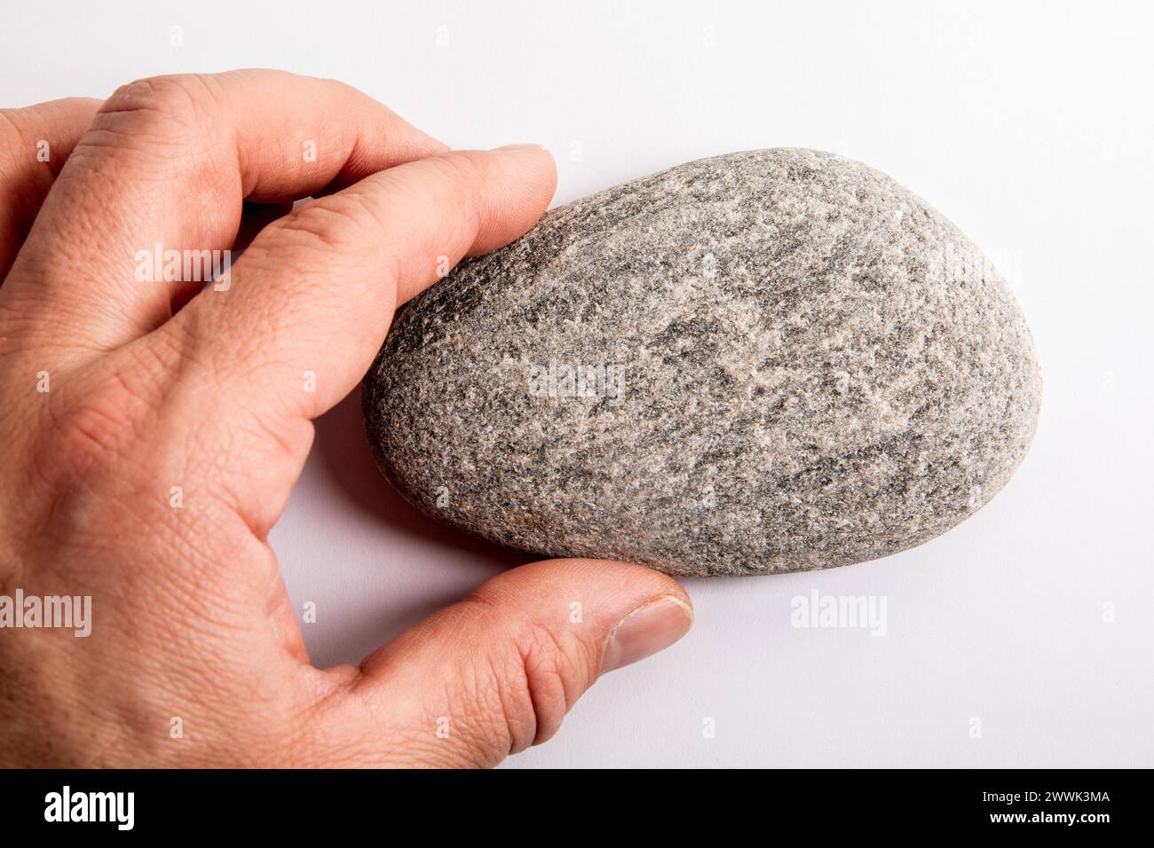 Flat stone in hand on white background Stock Photo - Alamy