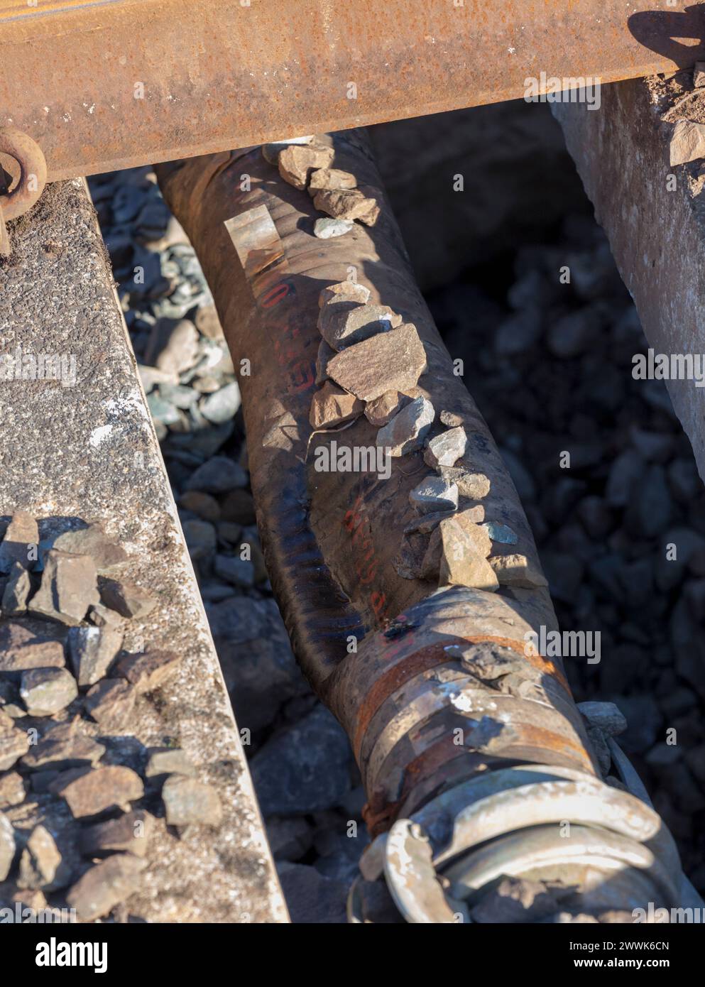 Pipe damaged by tamper packing ballast under sleepers that may have ...