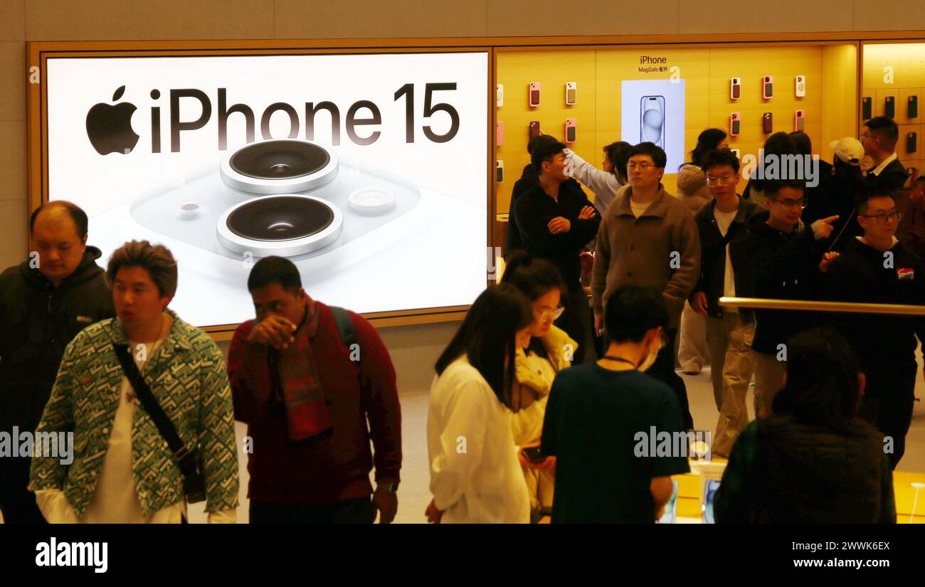 SHANGHAI, CHINA - MARCH 23, 2024 - Customers walk past the Apple iPhone ...