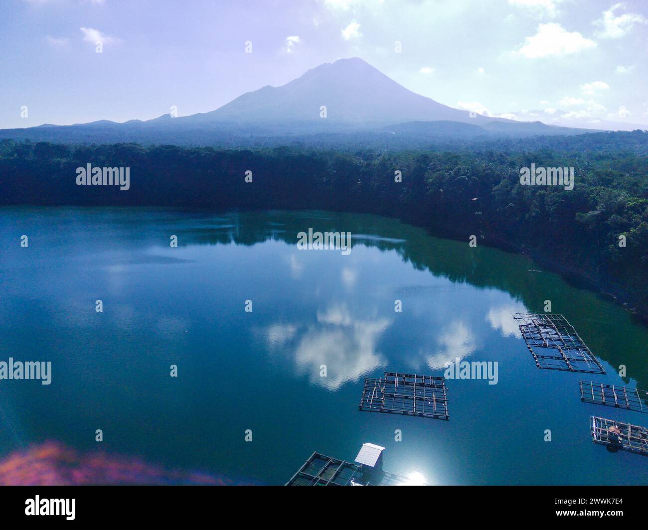 An aerial view of a clear blue lake with a dramatic, clouds capped ...